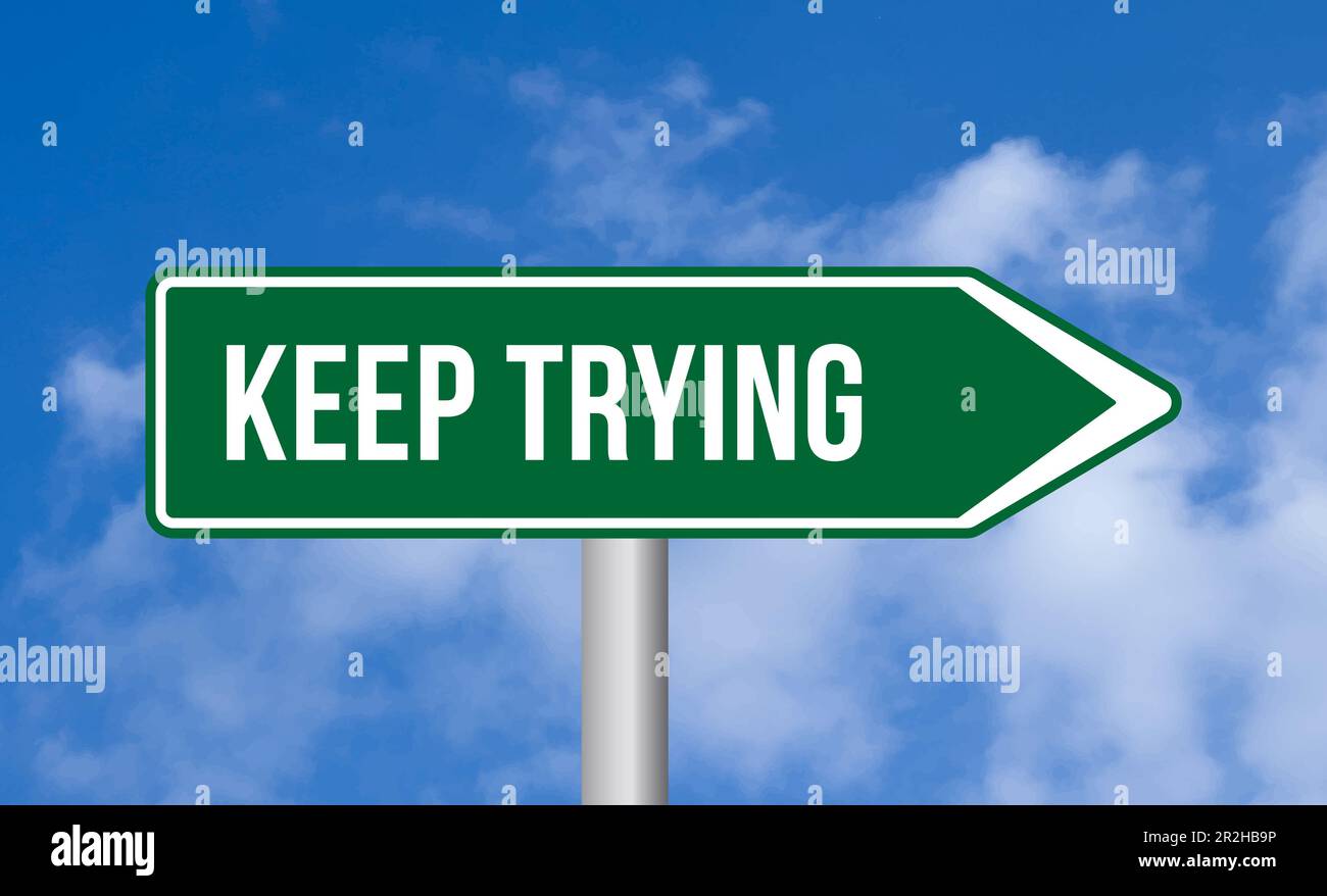 Keep trying road sign on blue sky background Stock Photo - Alamy