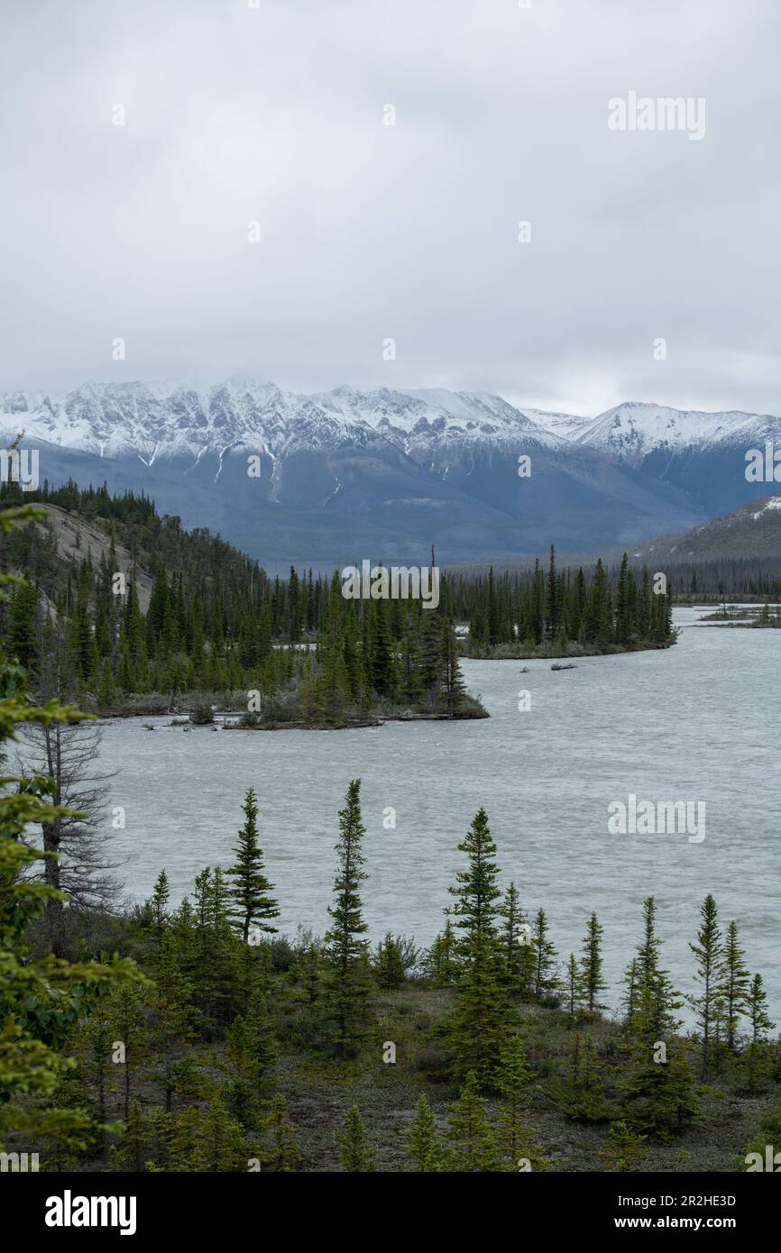 Beautiful turquoise waters lake with snow-covered peaks above it in ...