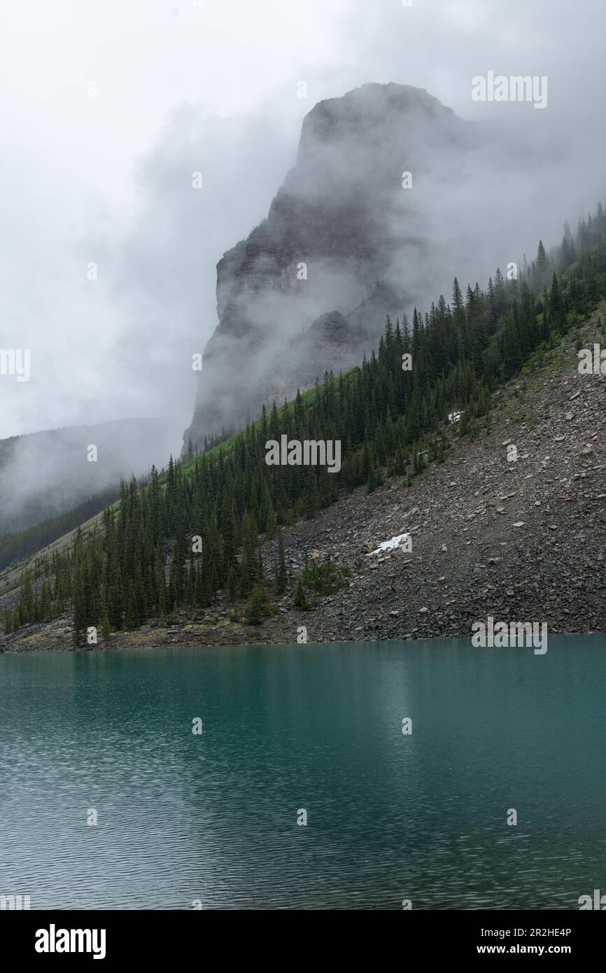 Beautiful turquoise waters lake with misty peaks in Banff National Park ...