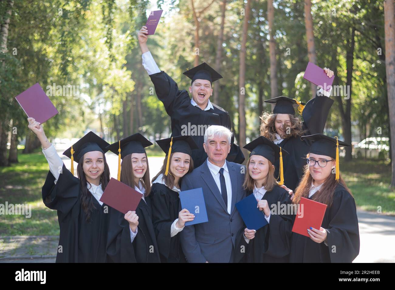 University professor and seven graduates rejoice at graduation Stock ...