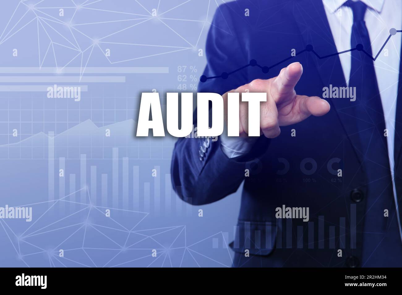 Audit concept. Businessman pointing at graph on light blue background ...