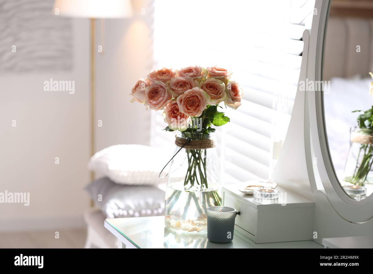 Glass vase with beautiful flowers on dressing table in modern room ...