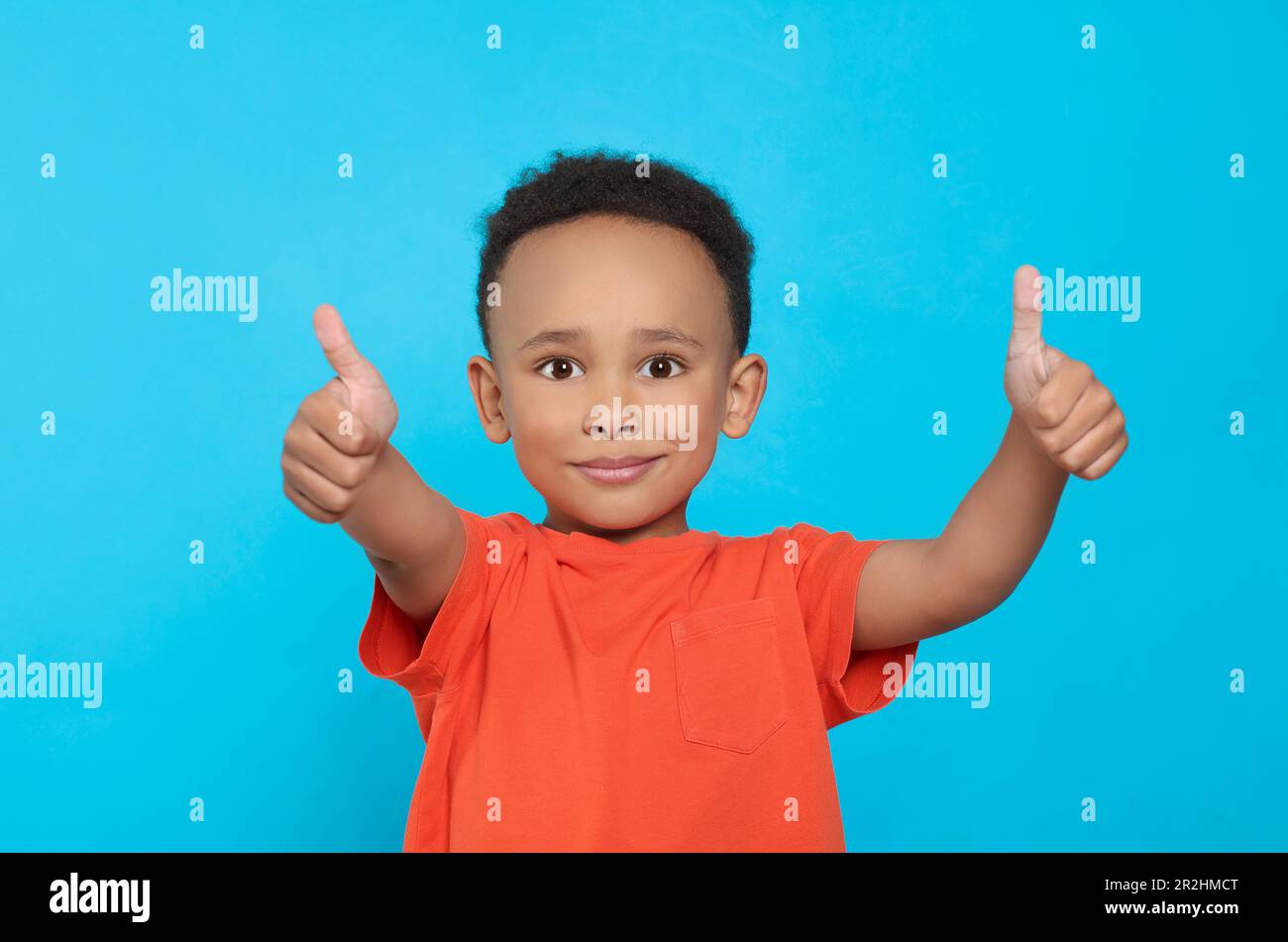 African-American boy showing thumbs up on turquoise background Stock ...