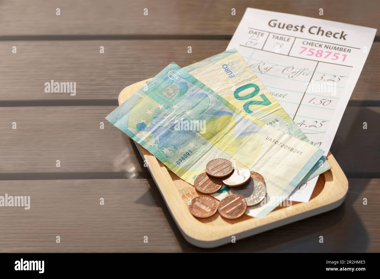 Wooden plate with payment for order and receipt on table, closeup ...