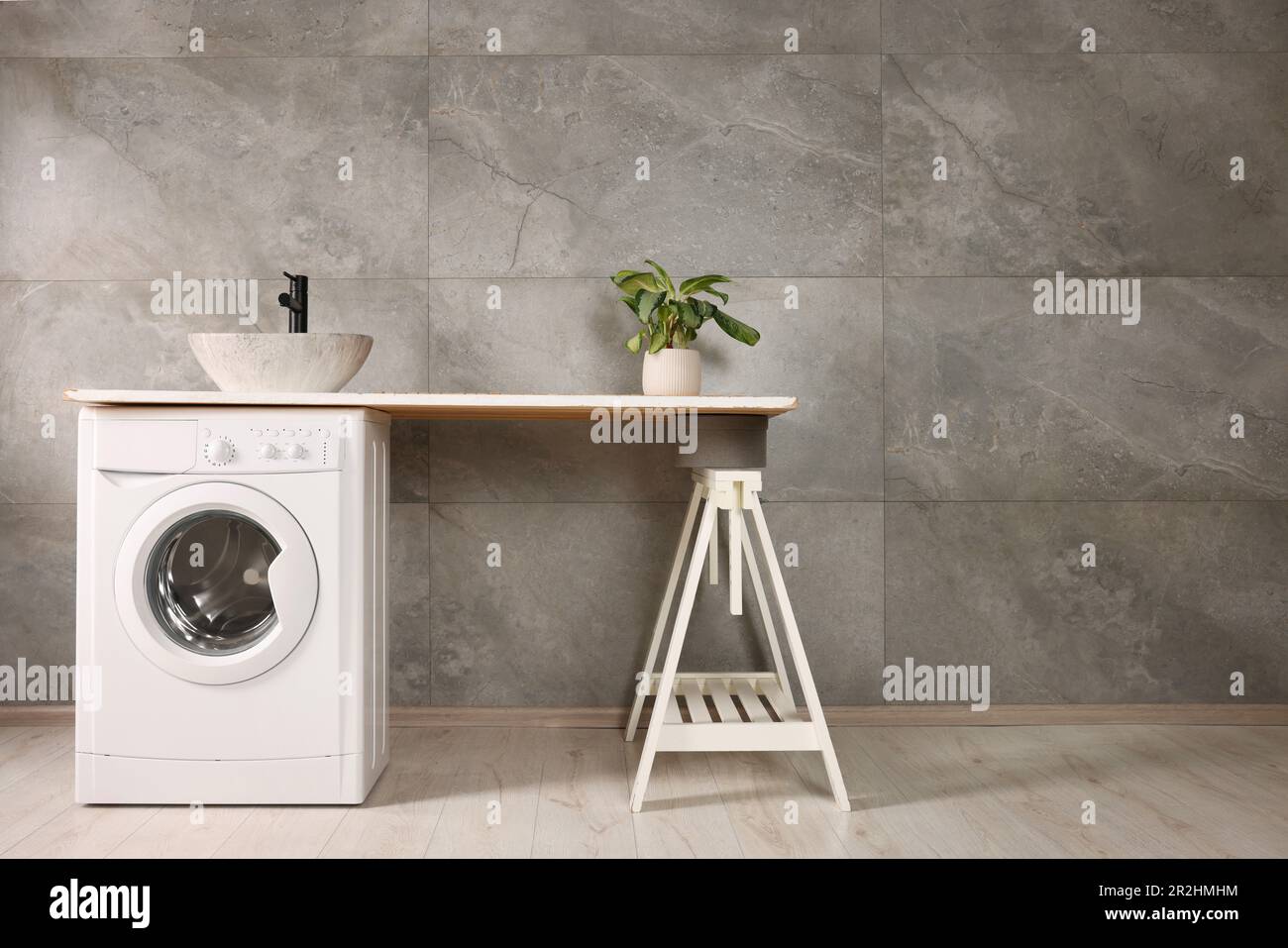 Stylish laundry room with modern washing machine, space for text ...