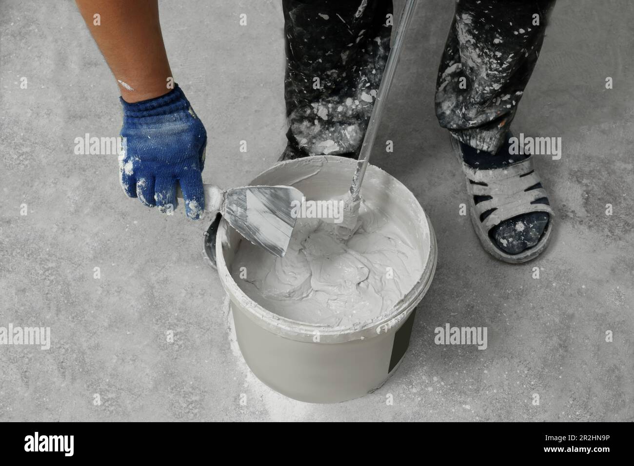 Professional worker mixing plaster in bucket indoors, closeup Stock ...