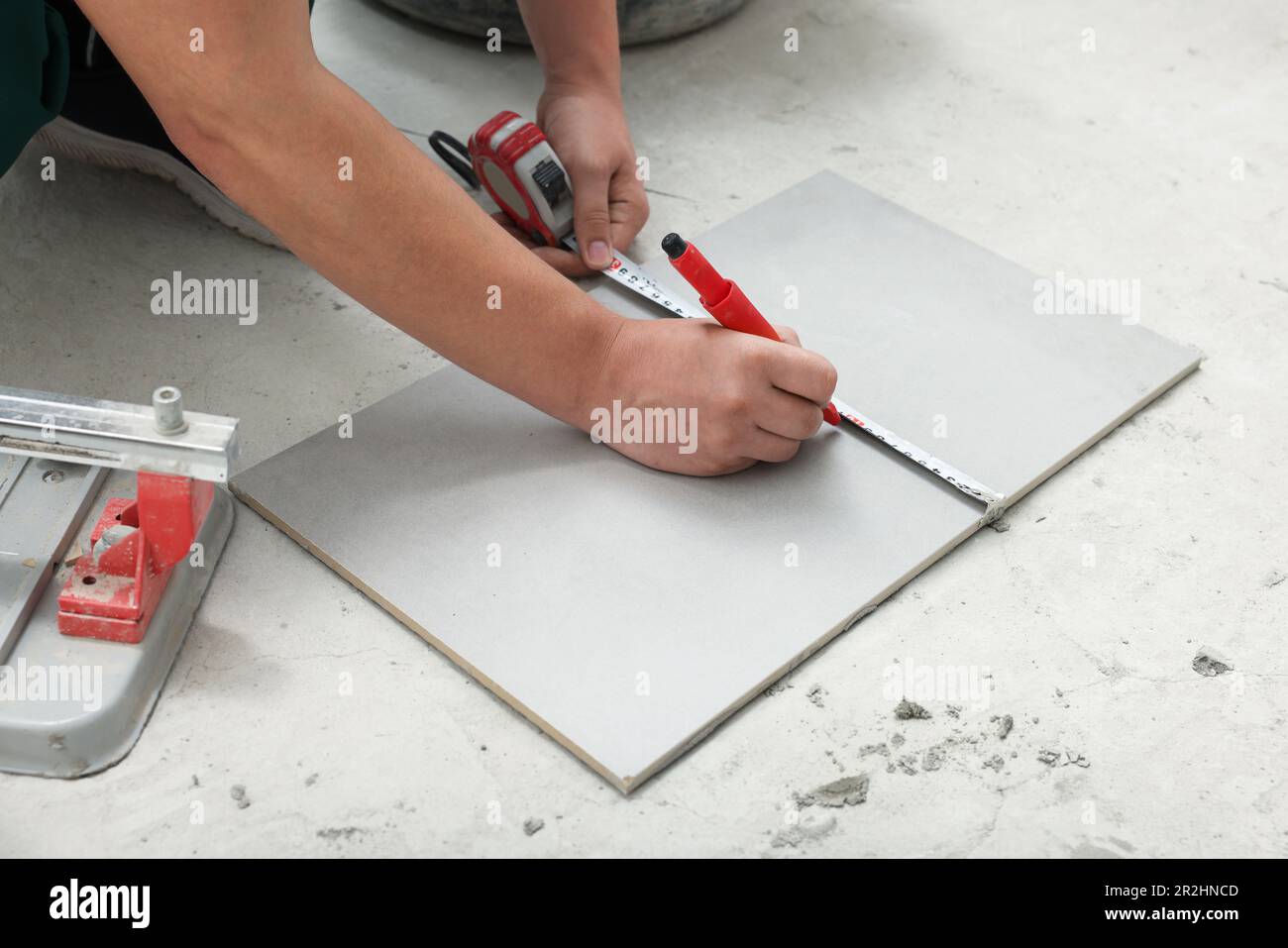 Worker measuring and marking ceramic tile on floor, closeup Stock Photo ...