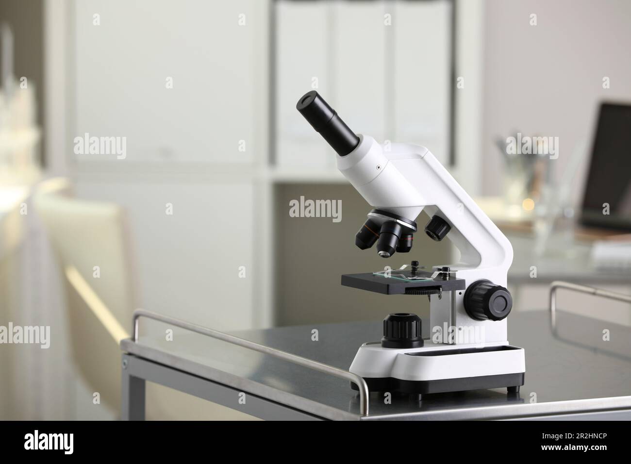 Modern medical microscope on metal table in laboratory, space for text ...