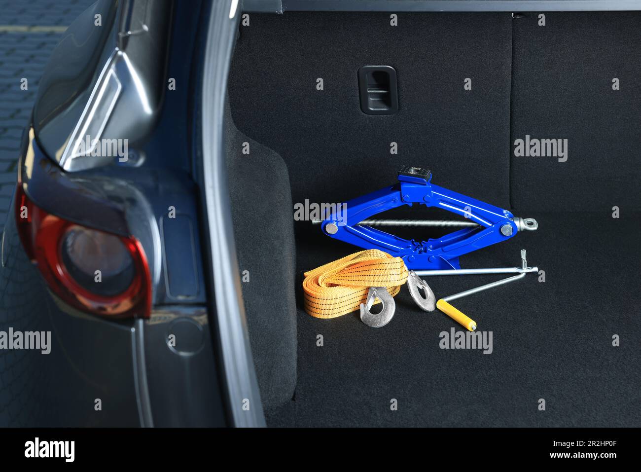 Scissor jack and towing strap in trunk. Car safety equipment Stock ...