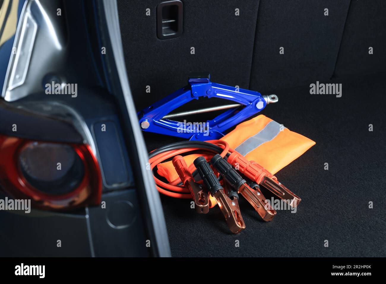 Scissor jack, life vest and battery jumper cables in trunk. Car safety ...