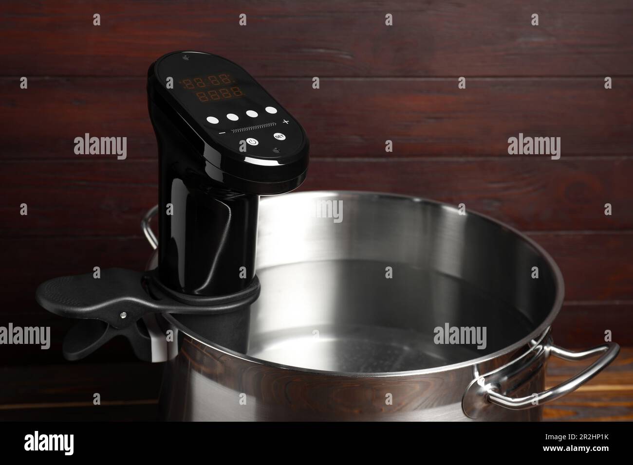Thermal immersion circulator in pot on wooden table. Sous vide cooker ...