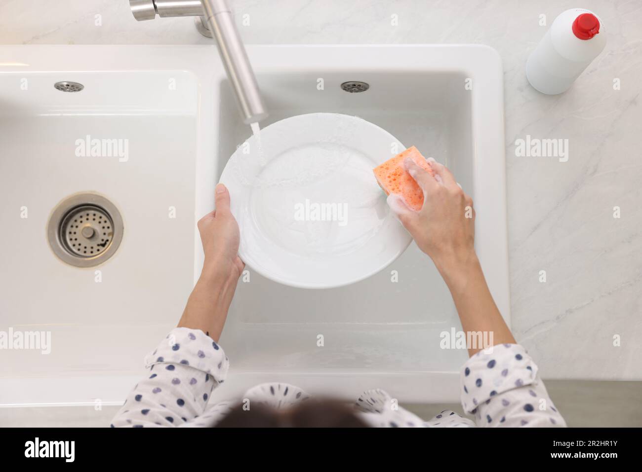Woman washing plate above sink in modern kitchen, top view Stock Photo ...