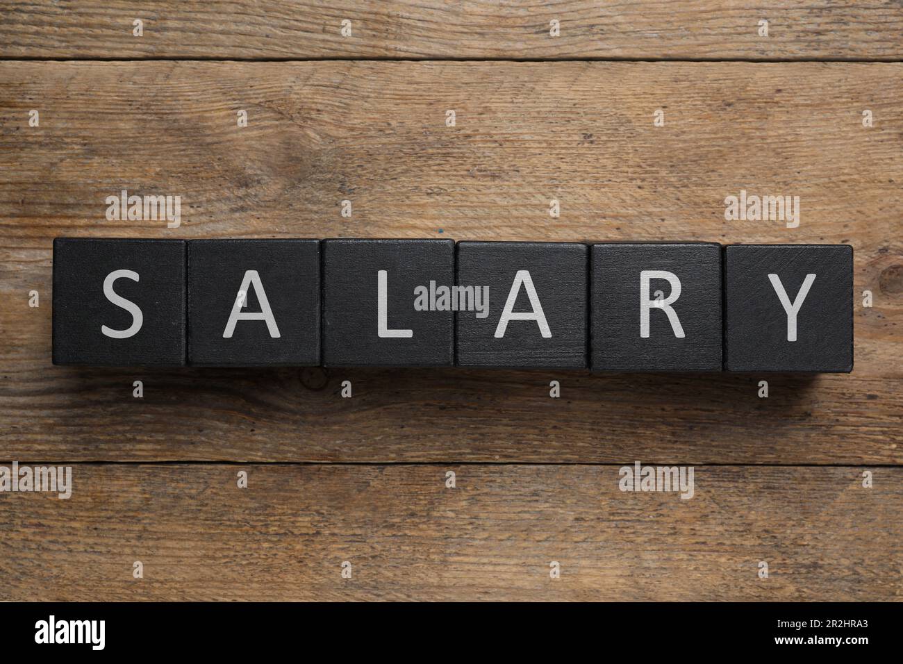 Word Salary made with black cubes on wooden table, flat lay Stock Photo ...