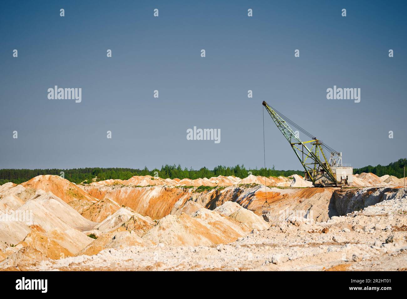 Walking excavator operates in chalk quarry with piles line Stock Photo ...