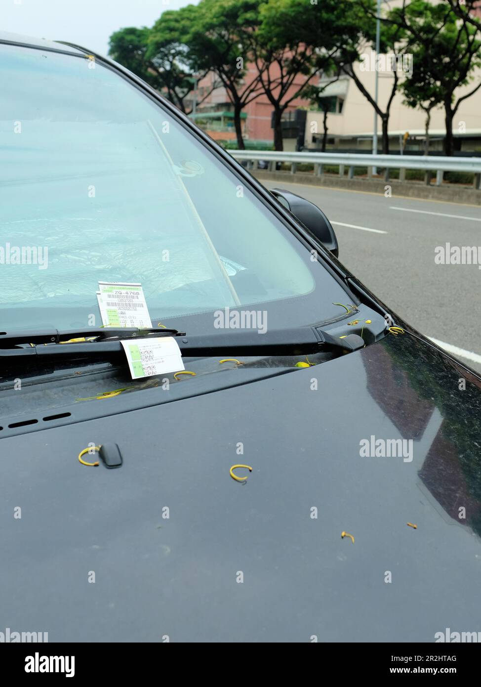Car windshield with parking ticket in Kaohsiung, Taiwan; white slips ...