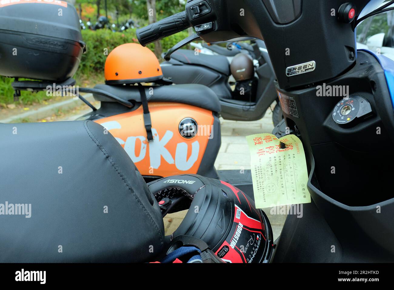 Motor scooter with parking ticket in Kaohsiung, Taiwan; yellow slips ...
