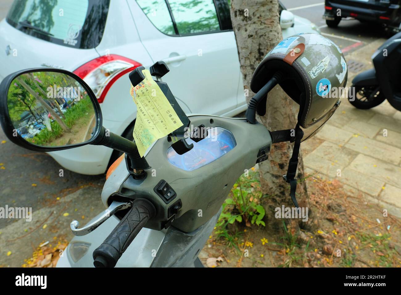 Motor scooter with parking ticket in Kaohsiung, Taiwan; yellow slips ...