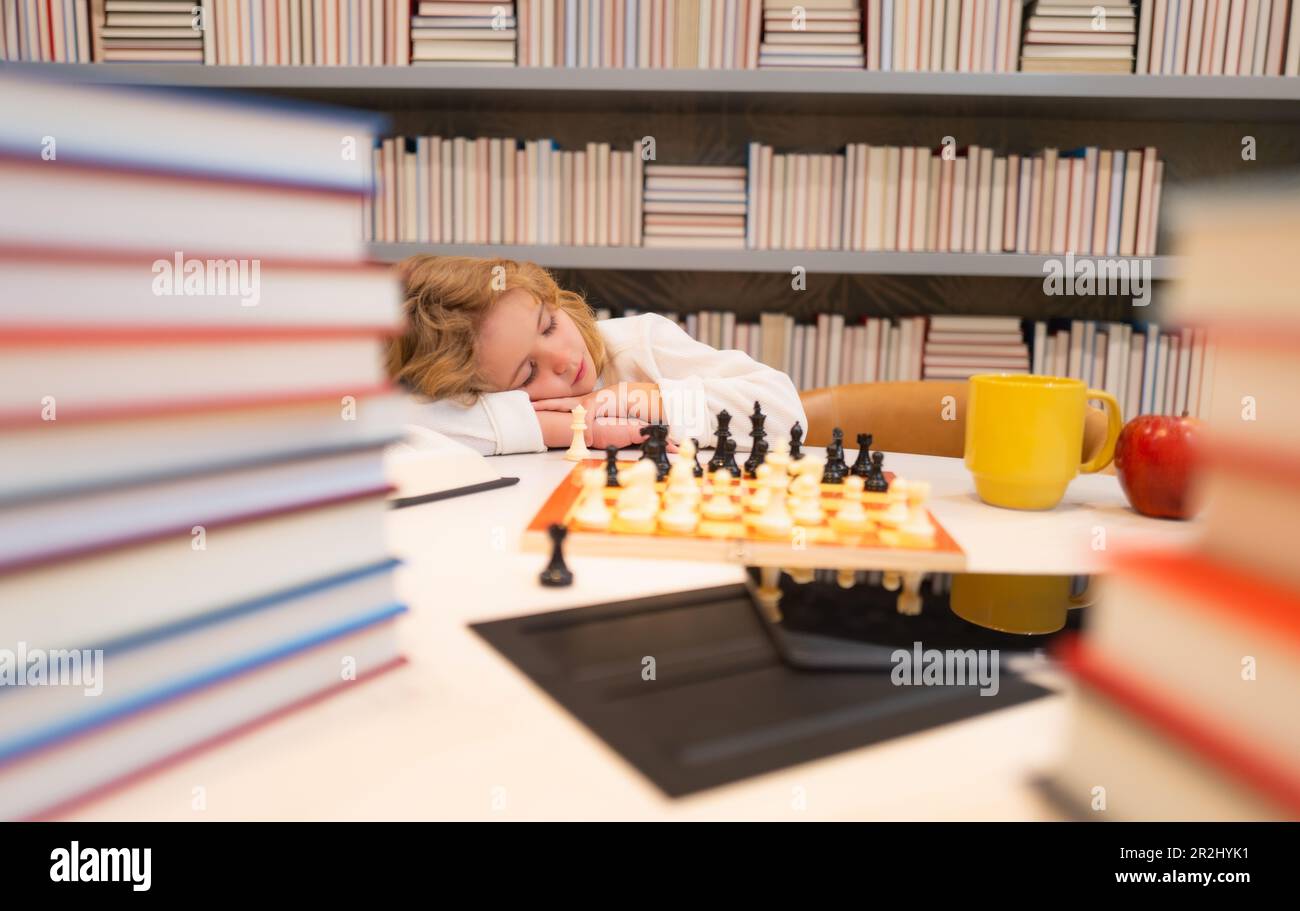 Tired and boring school. Child boy developing chess strategy, playing ...