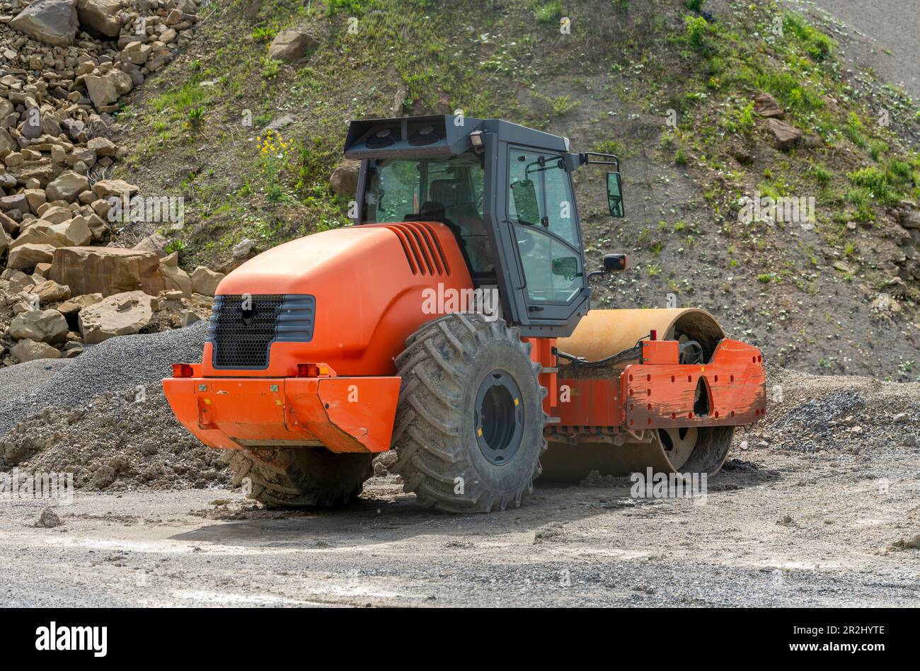 Red roller compactor at a construction site in sunny ambiance Stock ...