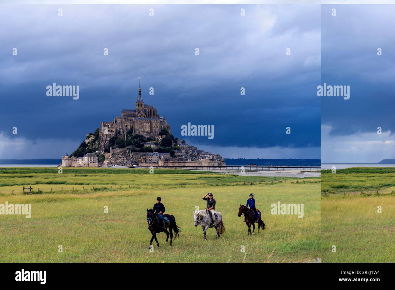 Horsemen in front of the Mont Saint-Michel monastery hill, Le Mont ...