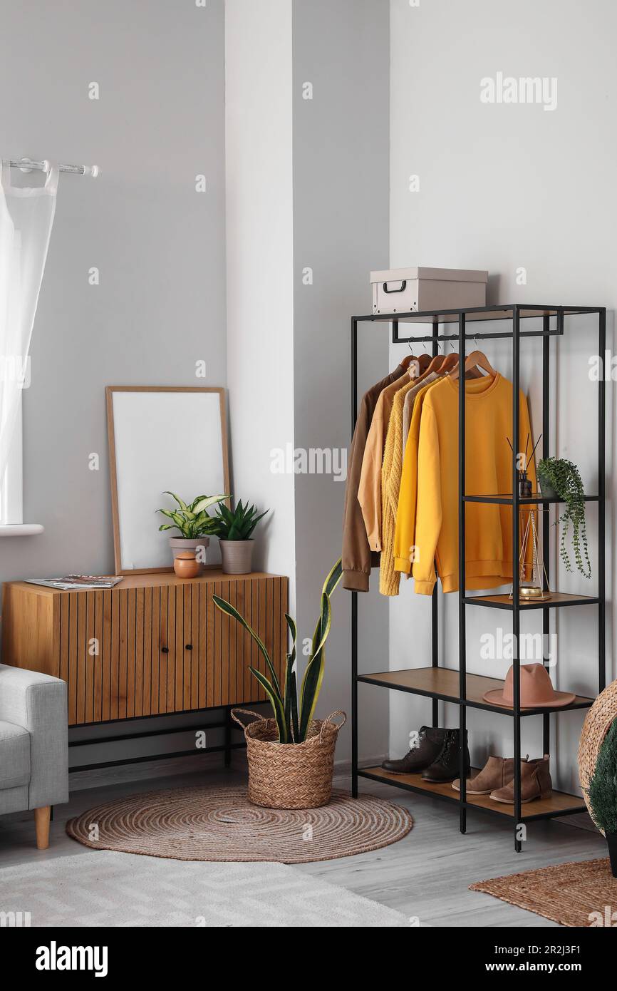 Interior of light living room with shelving unit and clothes Stock ...