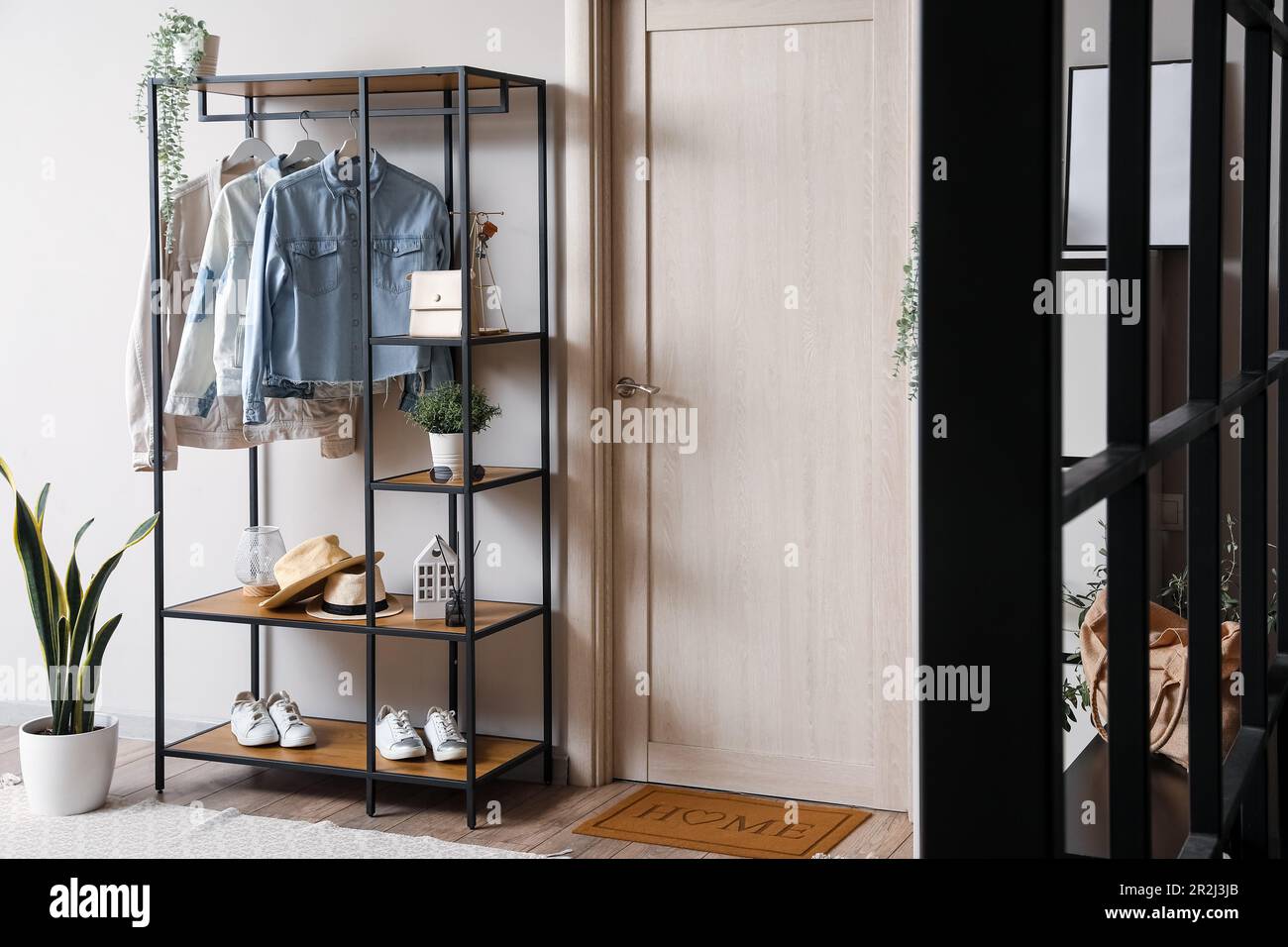 Shelving unit with clothes and accessories in interior of modern hall ...