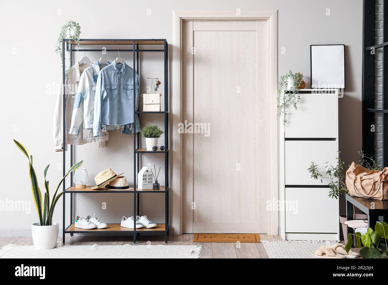 Interior of modern hall with shelving unit, clothes and drawers Stock ...