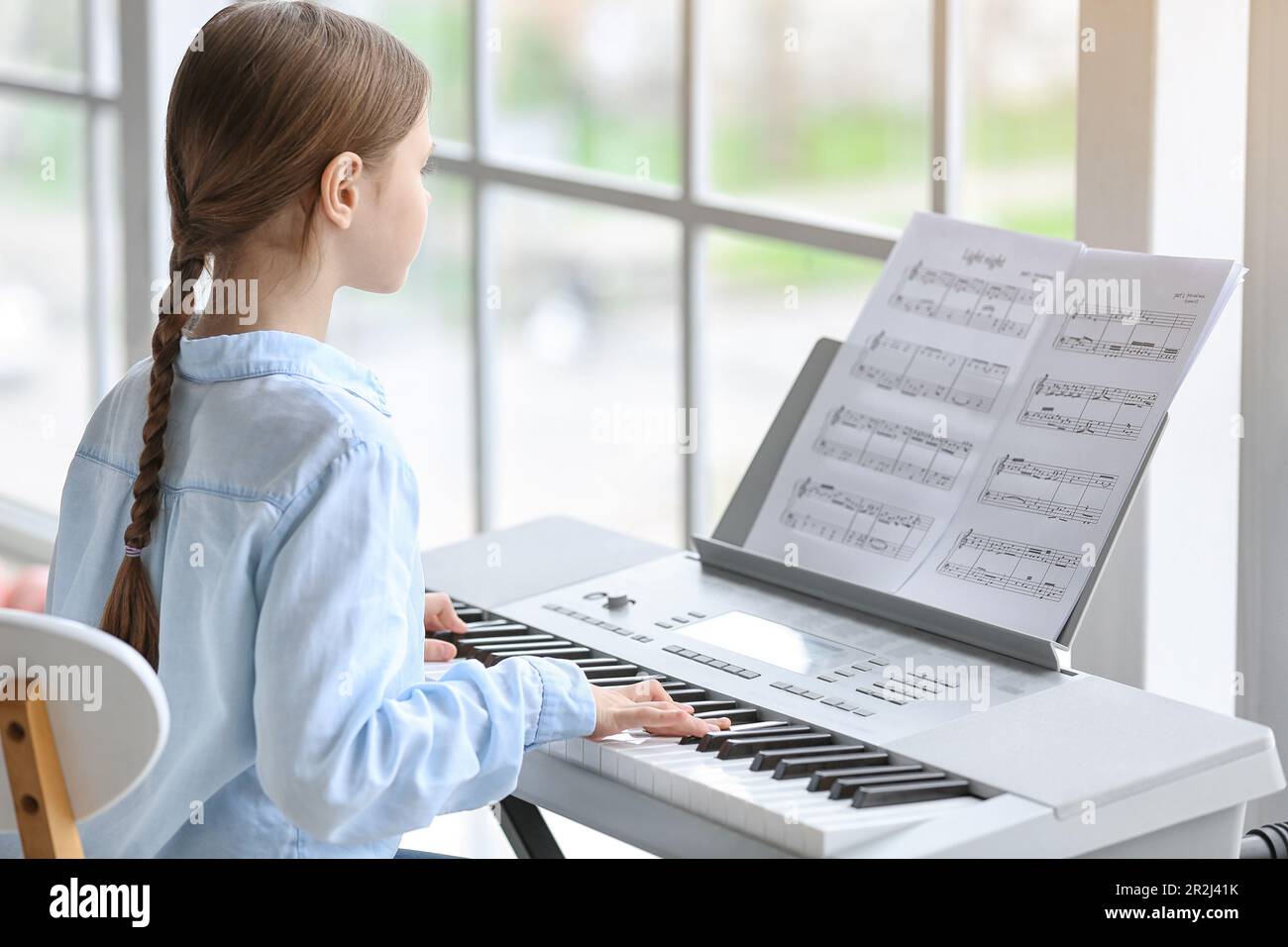 Little girl playing synthesizer at home Stock Photo - Alamy