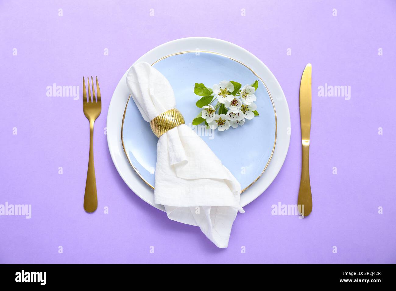 Beautiful table setting with folded napkin and blooming tree branch on ...