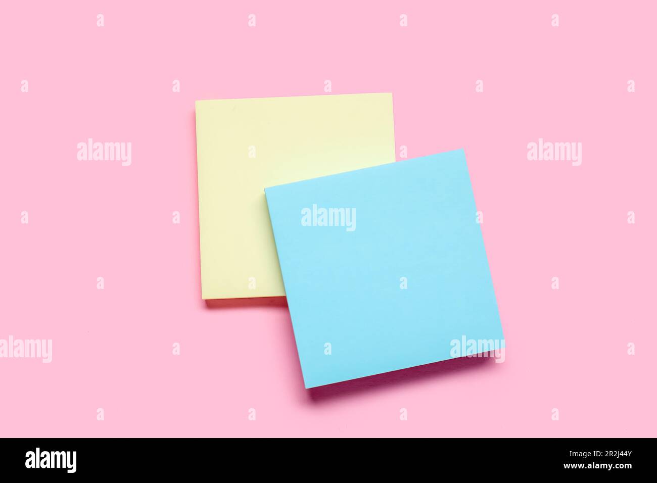 Sticky notes on pale pink background Stock Photo - Alamy