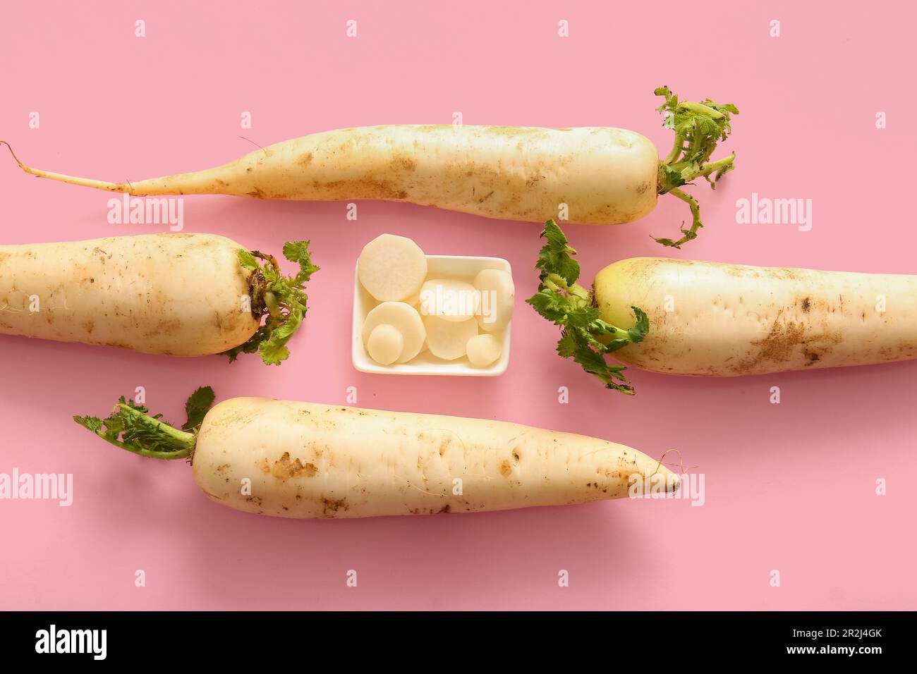 Fresh daikon radishes on pink background Stock Photo - Alamy