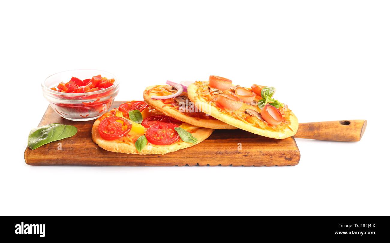 Board with different tasty mini pizzas and ingredients on white ...