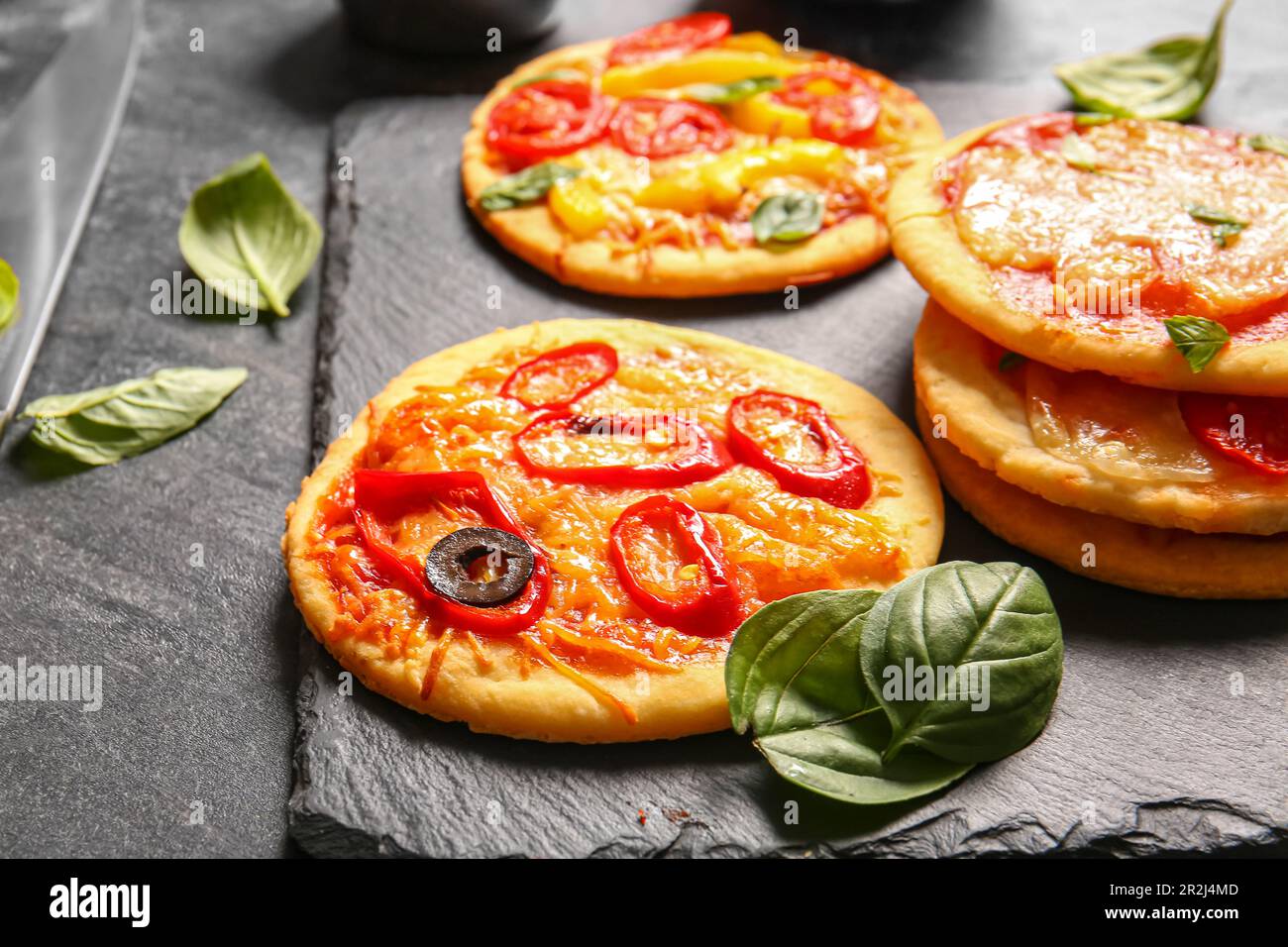 Board with different tasty mini pizzas on black background Stock Photo ...