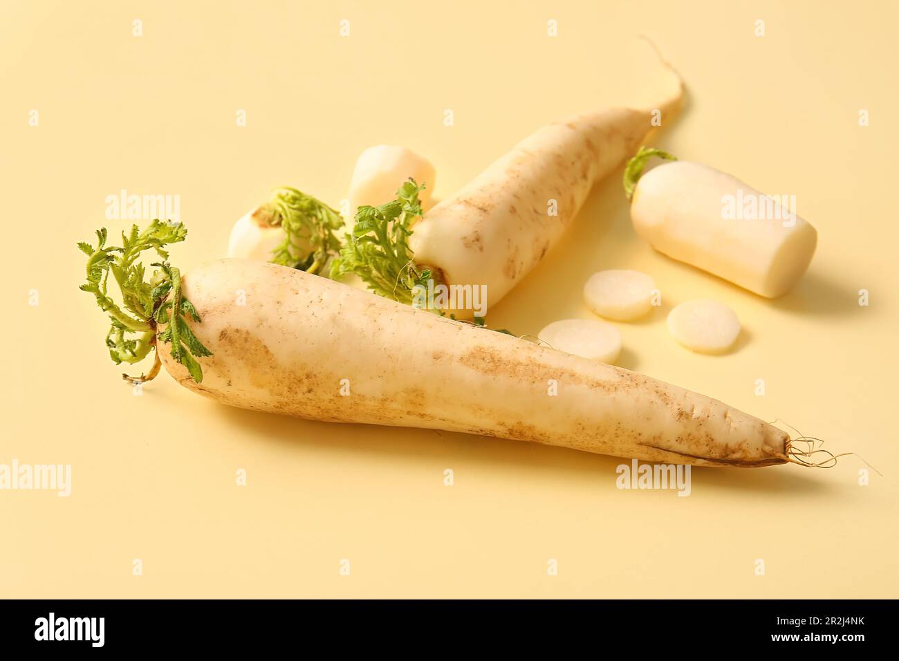 Fresh daikon radishes on yellow background Stock Photo - Alamy