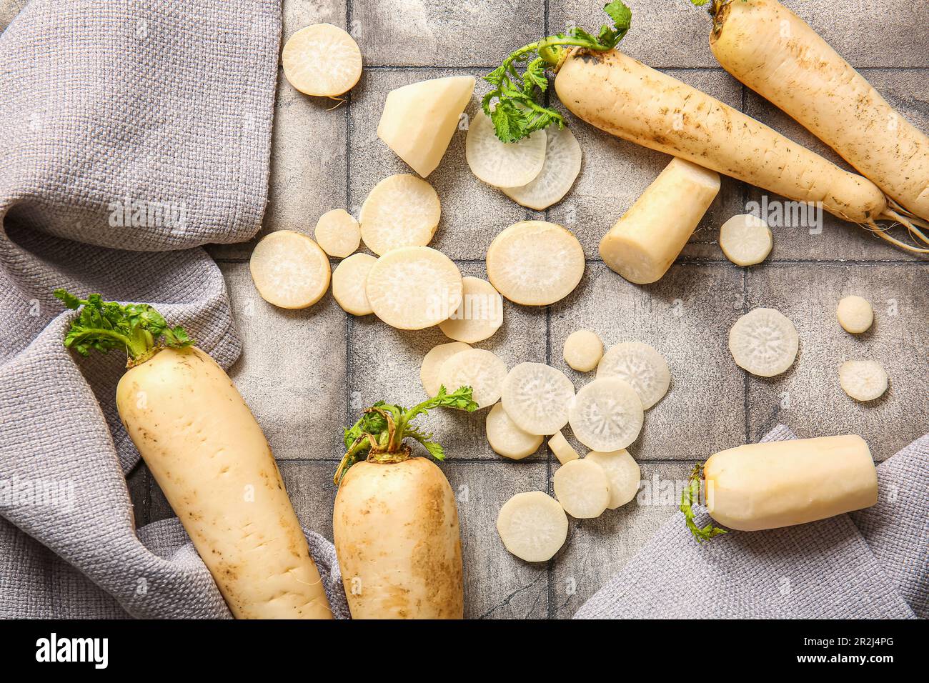 Fresh daikon radishes on grey tile background Stock Photo - Alamy