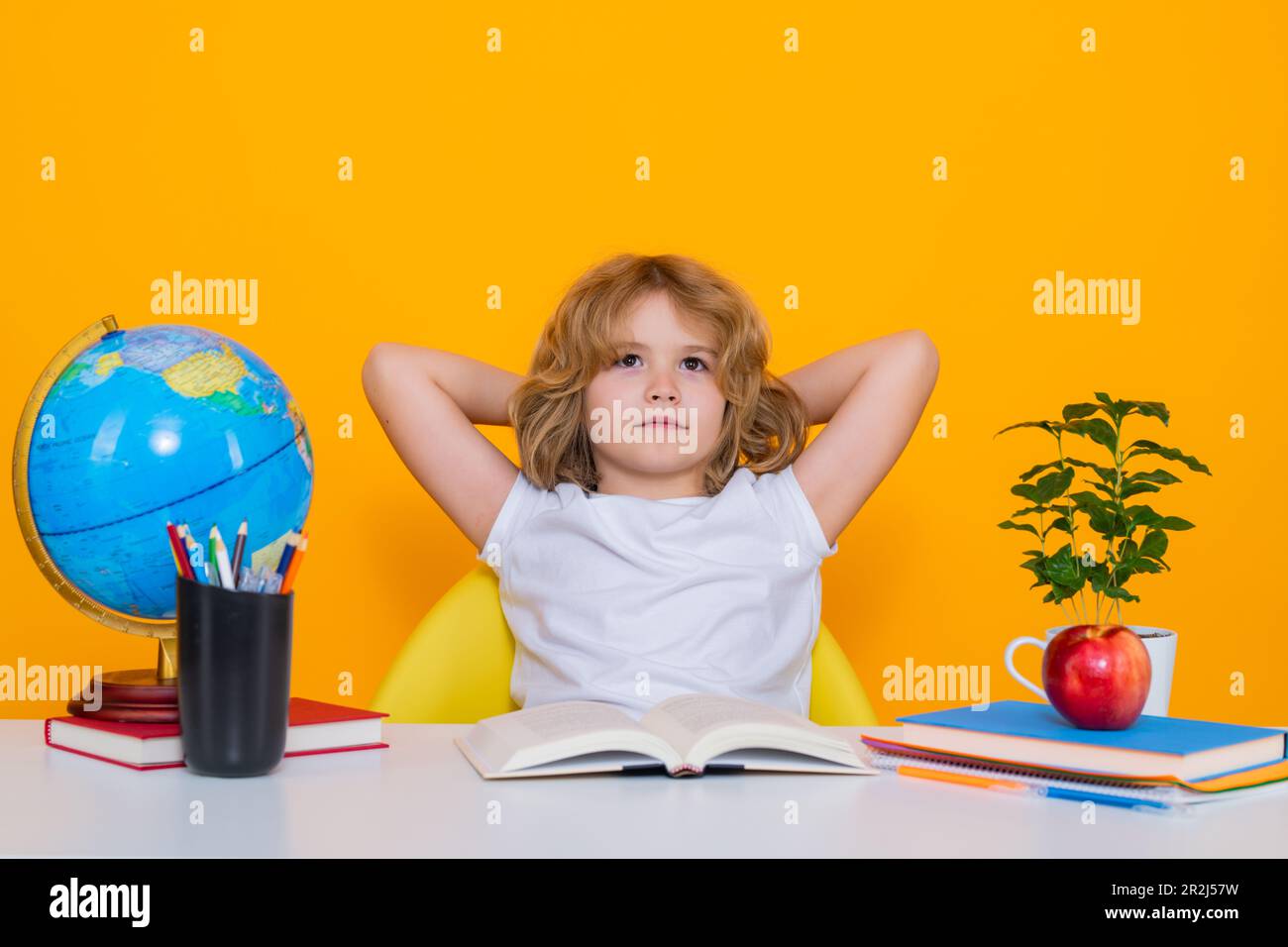 Nerd pupil boy from elementary school with book isolated on yellow ...