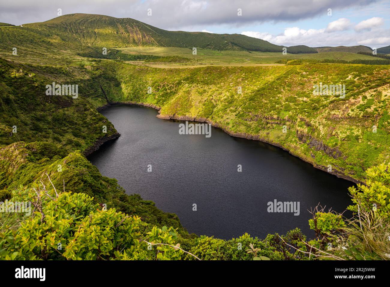 The black lagoon Lagoa Negra in a lush landscape from the crater of the ...