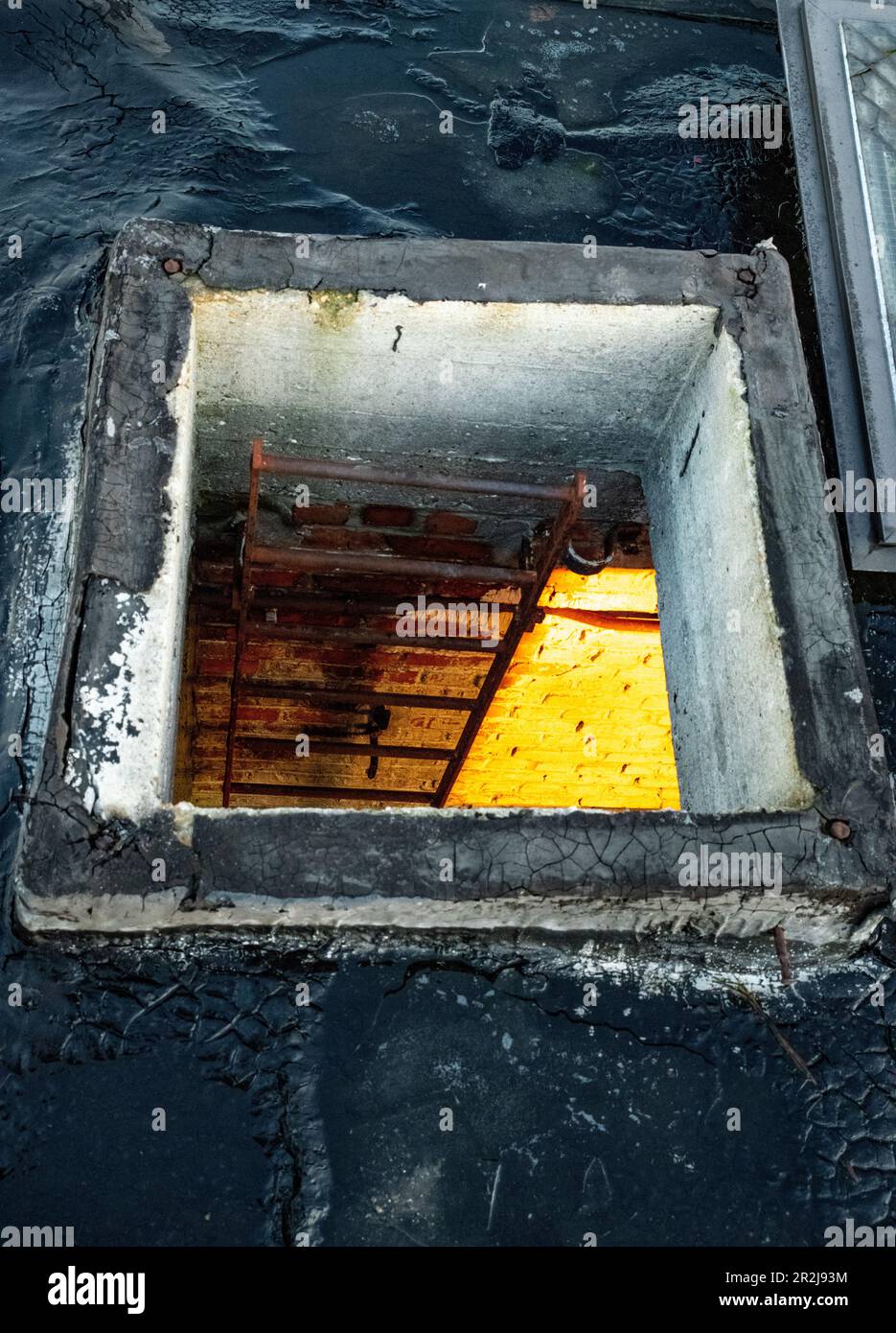 Manhole with ladder leading down from roof Stock Photo - Alamy