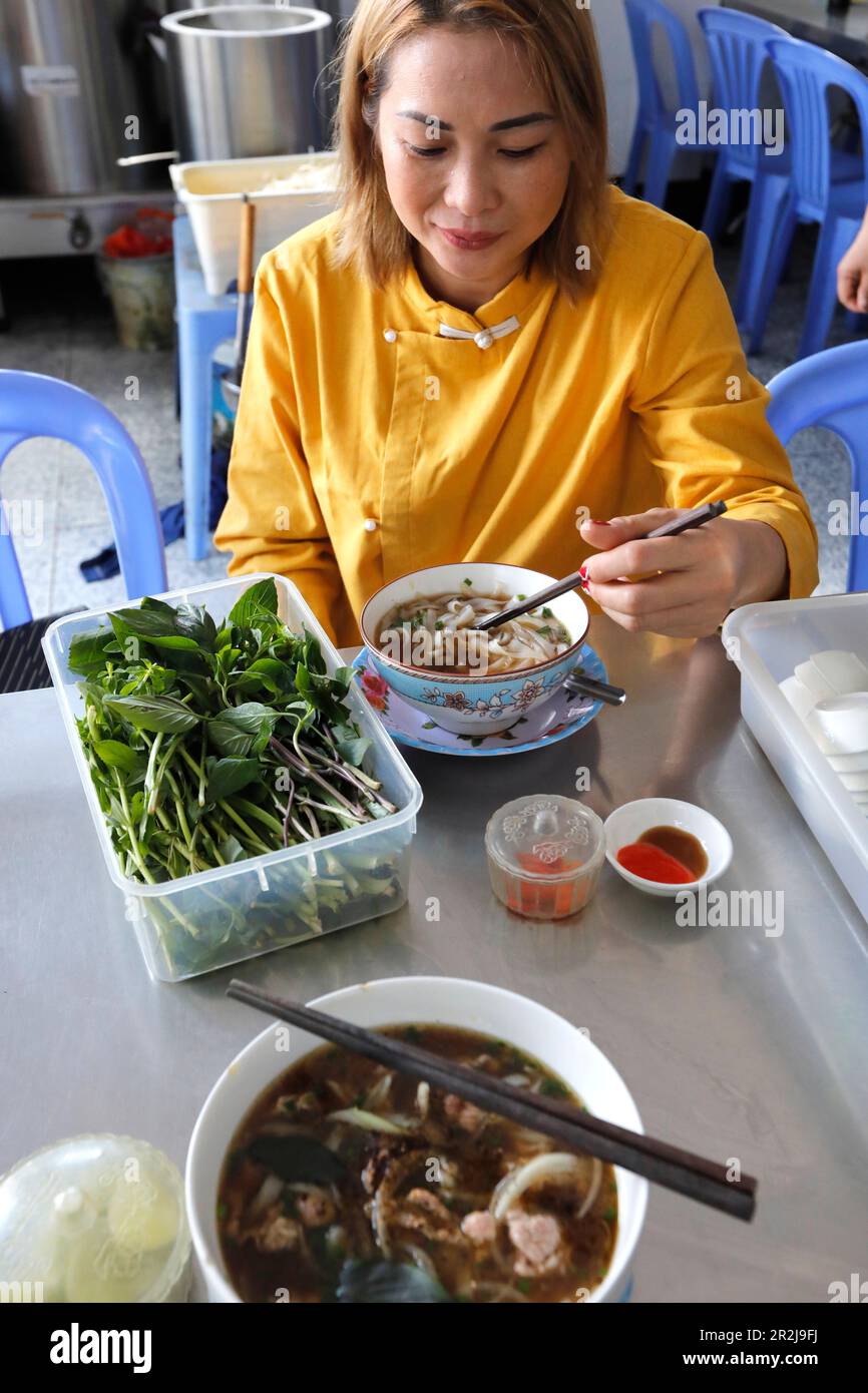 Woman eating traditional Vietnamese soup Pho, Tan Chau, Vietnam ...