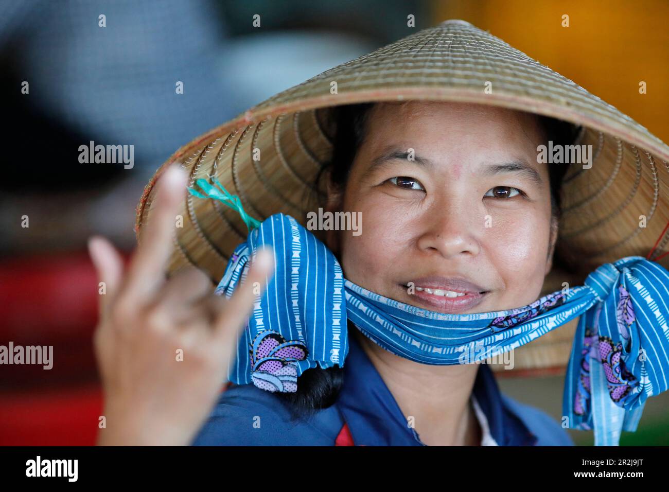 Woman with the traditional Vietnamese conical hat working in a fish ...