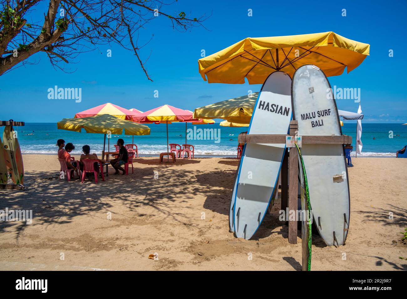 View of sunshades and surf boards on sunny morning on Kuta Beach, Kuta ...