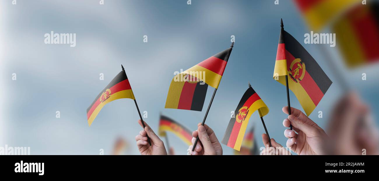 A group of people holding small flags of the DDR in their hands Stock ...