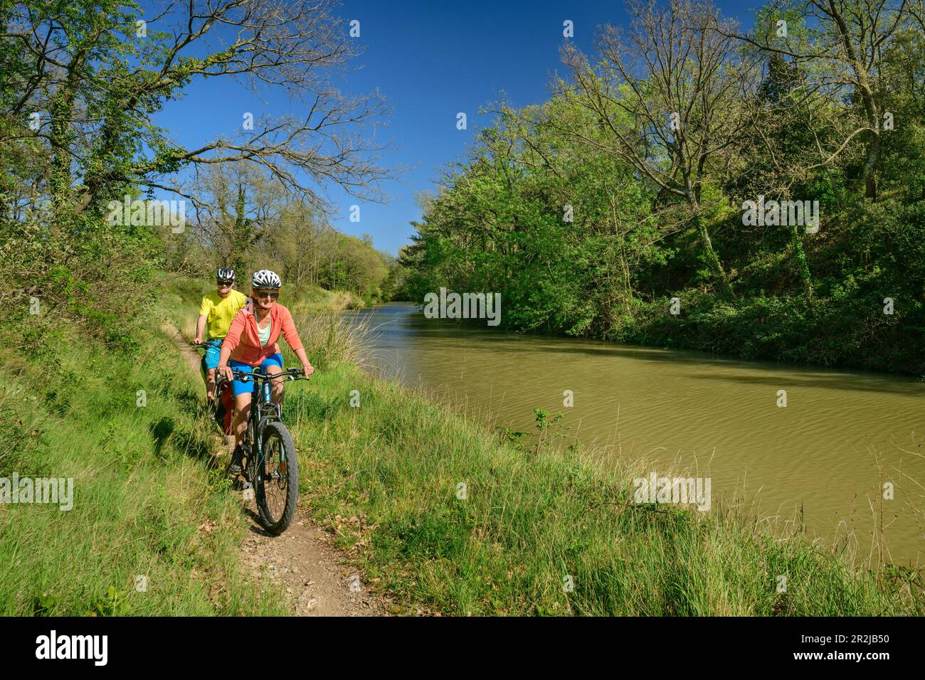 Two people cycling along the Canal du Midi, near Marseillette, Canal du ...