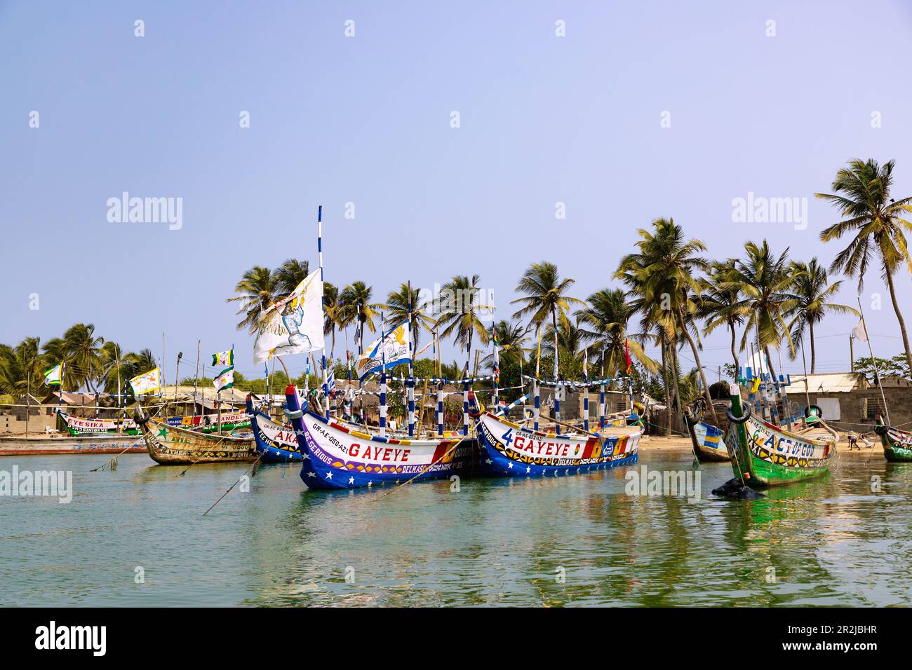 Ada Foah fishing village with painted fishing boats on the banks of the ...