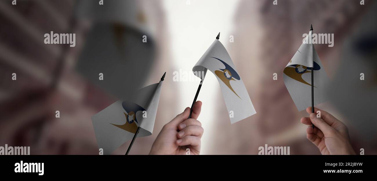 A group of people holding small flags of the Eurasian Economic Union in ...