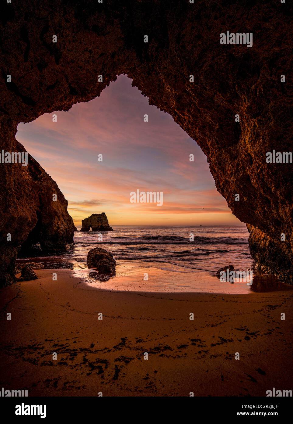 View through a rock gate in the light of dawn to the sea, Praia dos ...