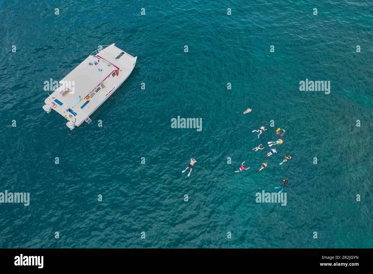 Aerial view of people swimming and snorkeling from a catamaran in ...