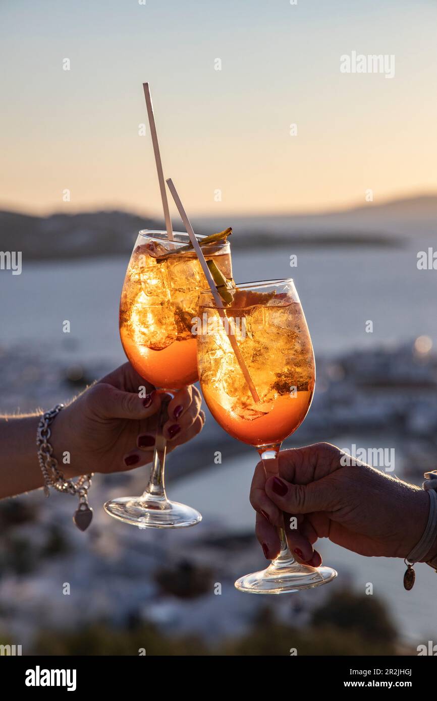 Hands of two women toasting with Aperol Spritz cocktails at 180º Sunset ...