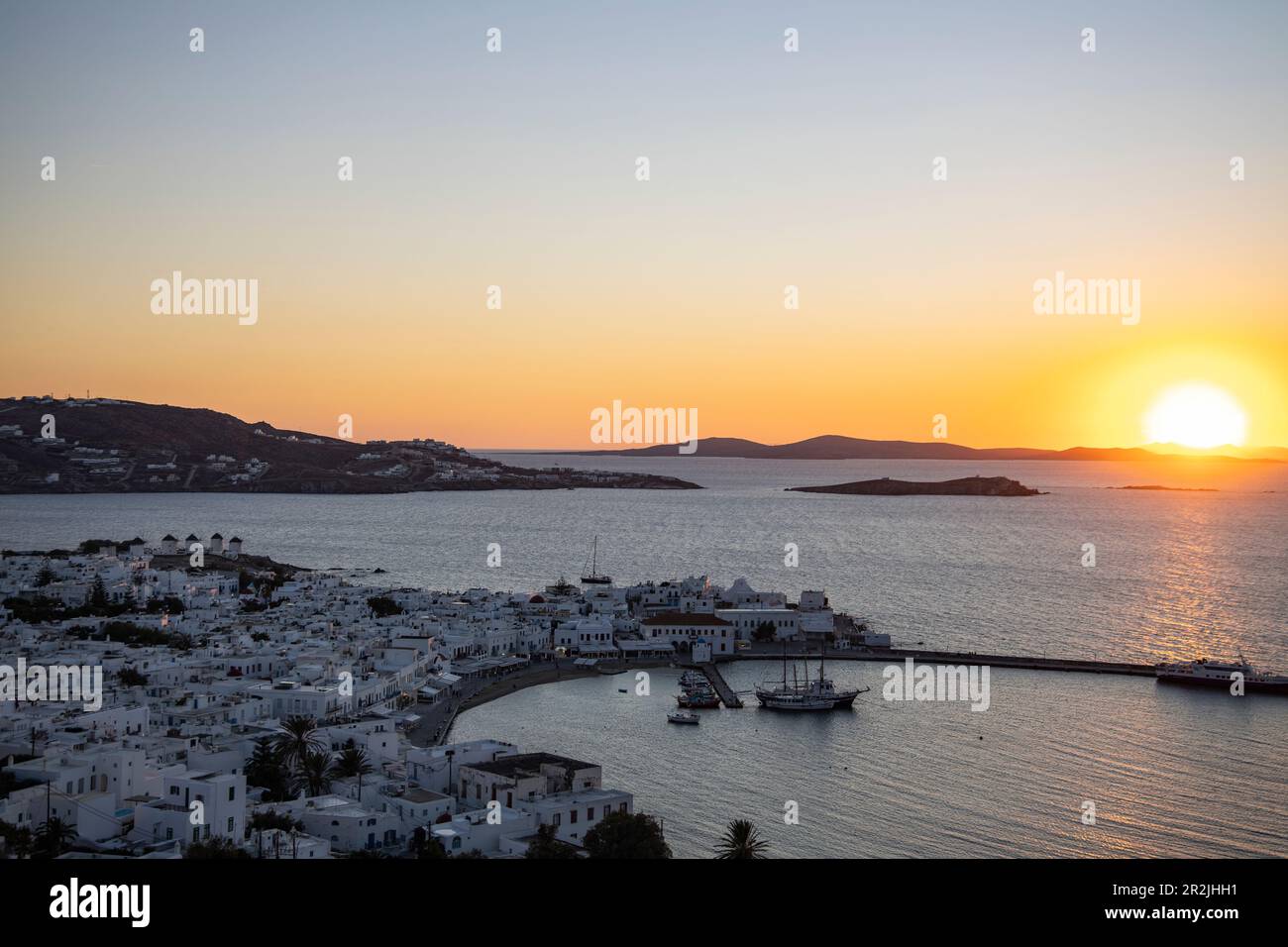 View over the town with the famous Mykonos windmills, harbor and ...