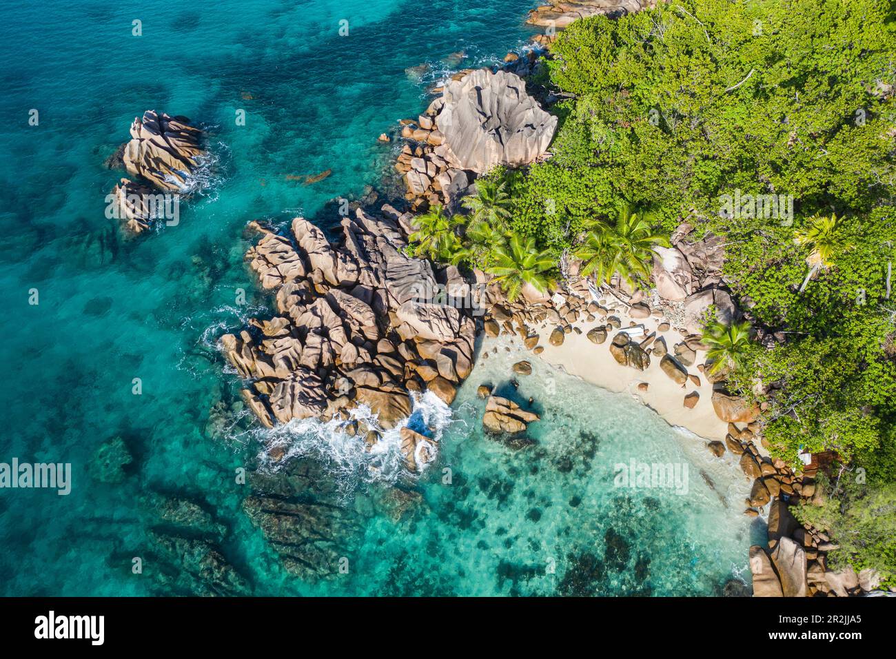 Aerial view of beach in a small bay with granite rocks, Curieuse Island ...